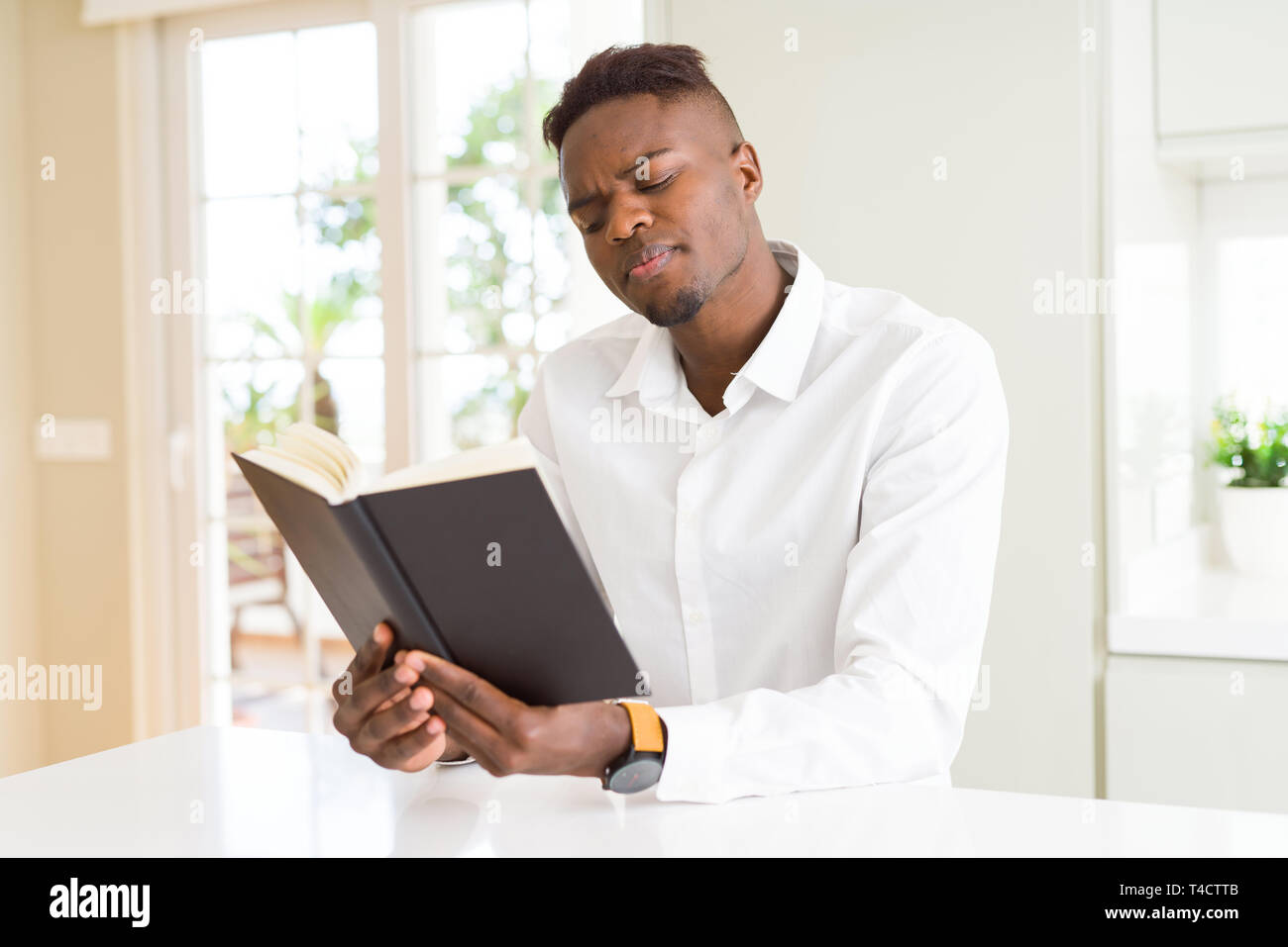 African man reading a book hi-res stock photography and images - Alamy