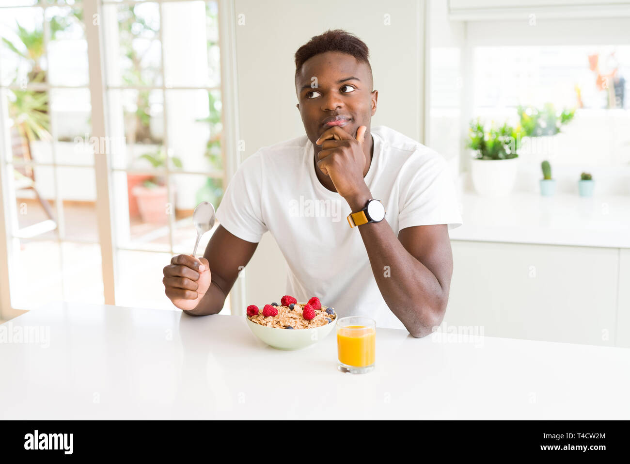 Young african american man eating healthy breakfast in the morning ...