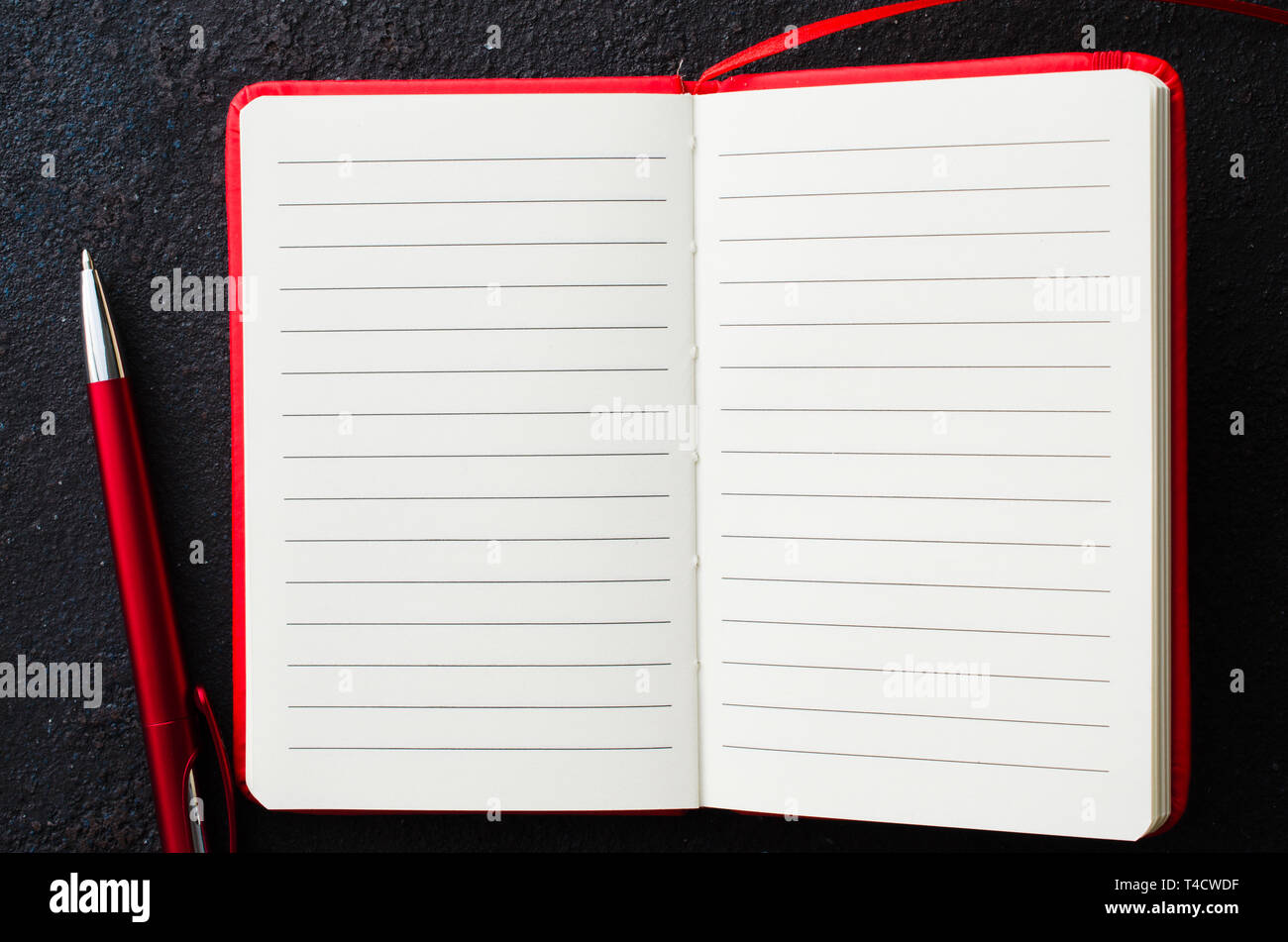 Empty open red notebook with red pen on dark background. Blank paper ...