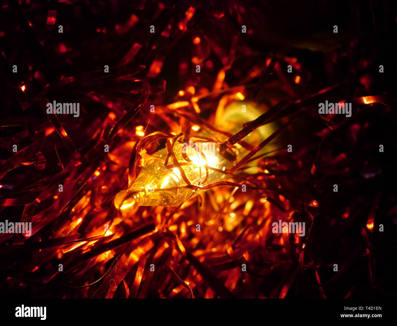 Macro shot of a single Christmas light surrounded by tinsel Stock Photo ...