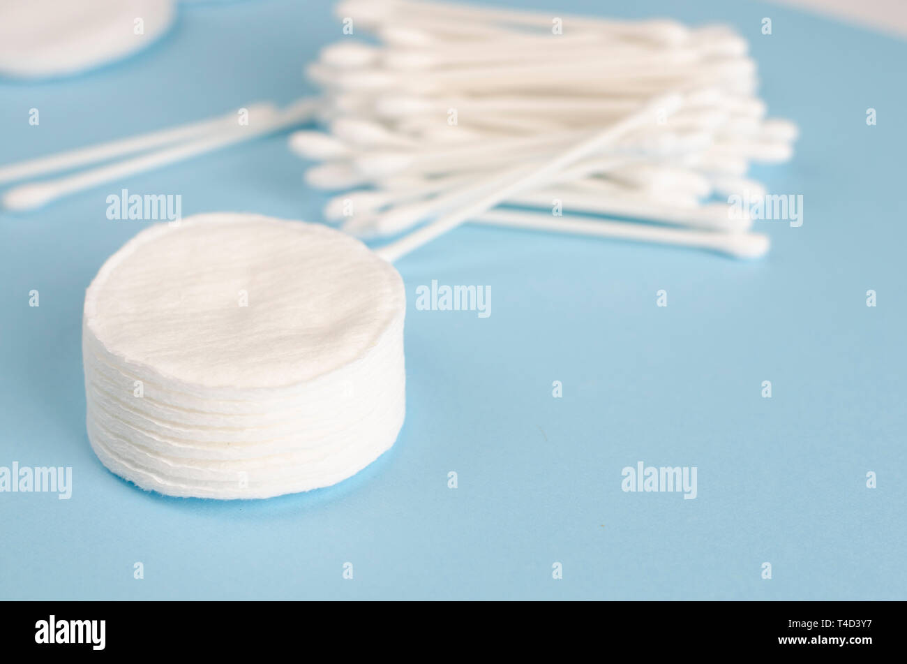 Ear sticks and cotton pads on pastel blue background. Makeup removal ...