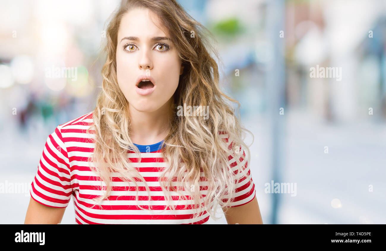 Beautiful young blonde woman over isolated background In shock face ...