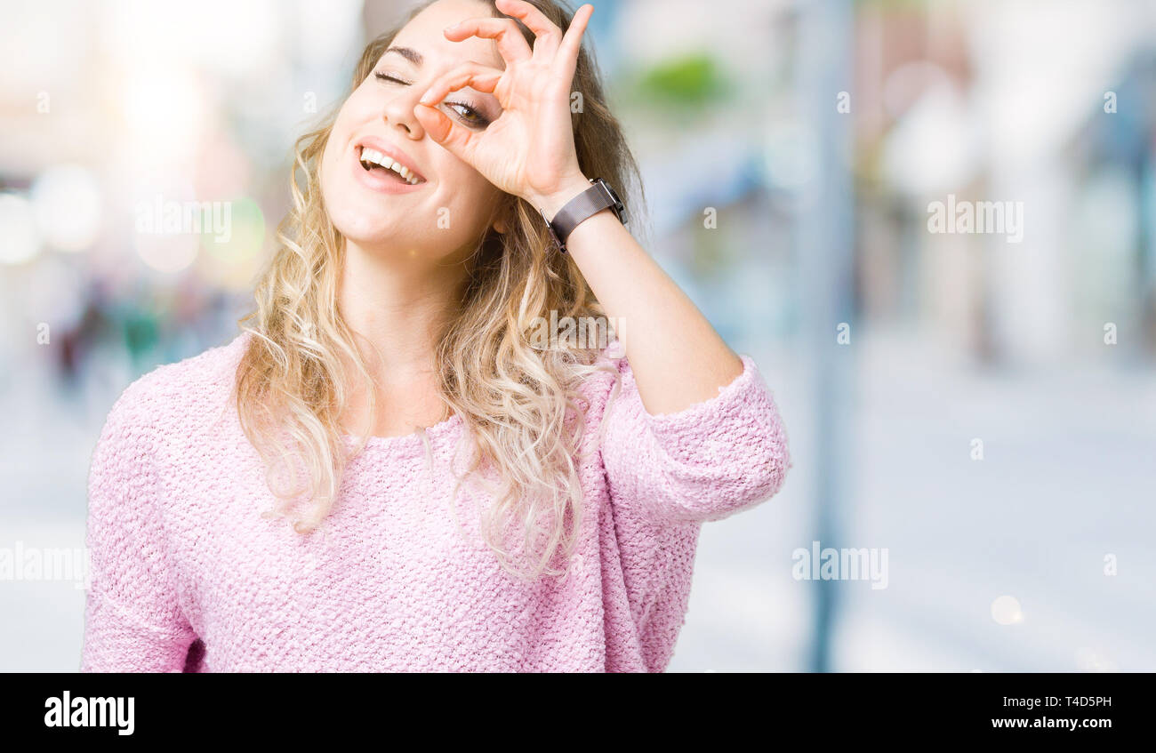Beautiful young blonde woman over isolated background doing ok gesture ...