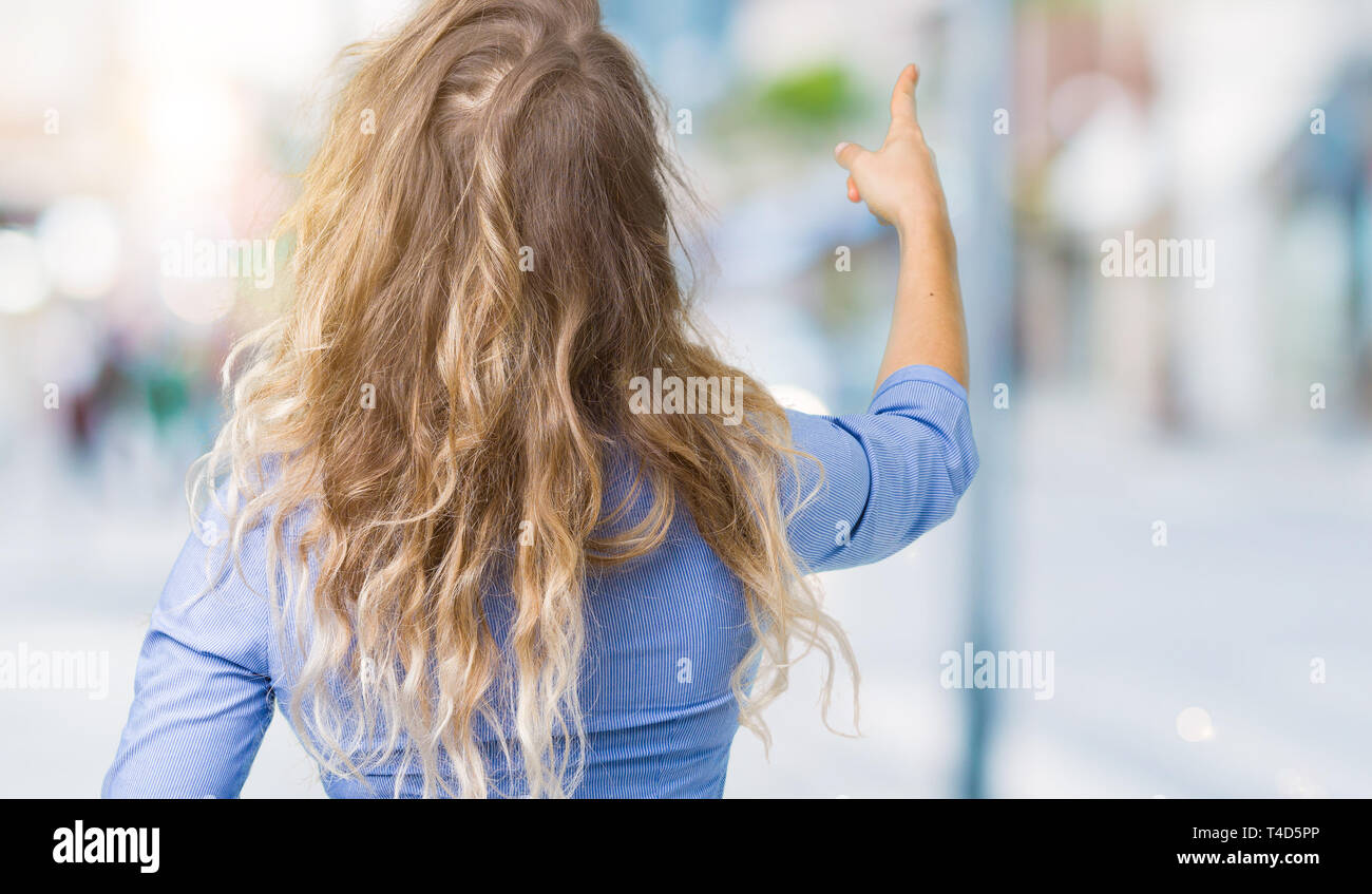 Beautiful young blonde business woman over isolated background Posing ...