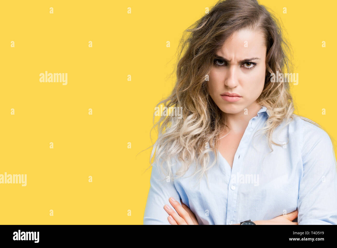 Beautiful young blonde business woman over isolated background skeptic ...