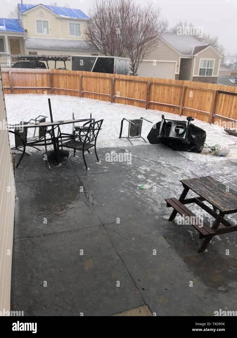 High wind gusts knock down patio furniture during a blizzard in ...