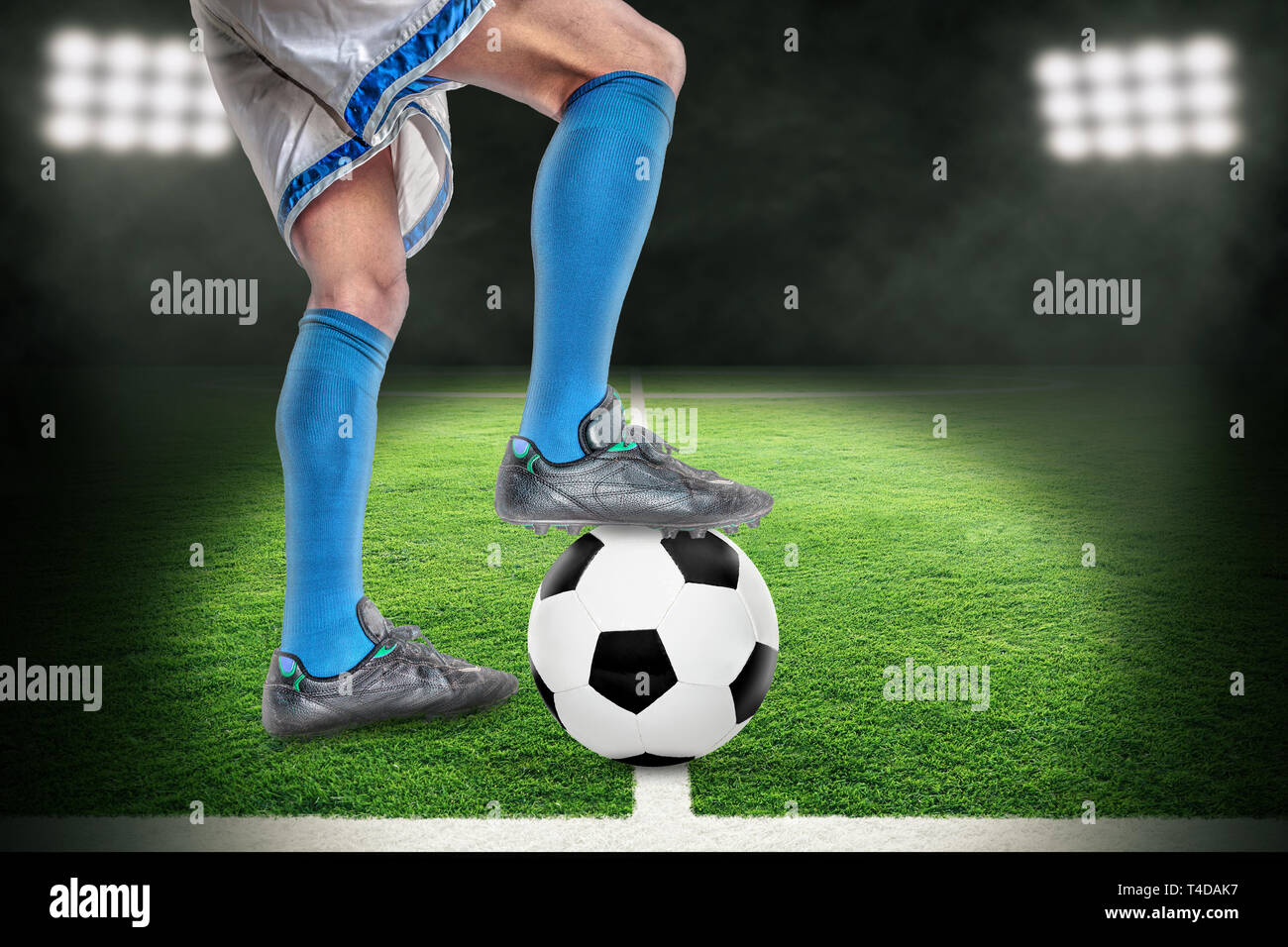 Spotlight on soccer player in action with football in brightly lit ...