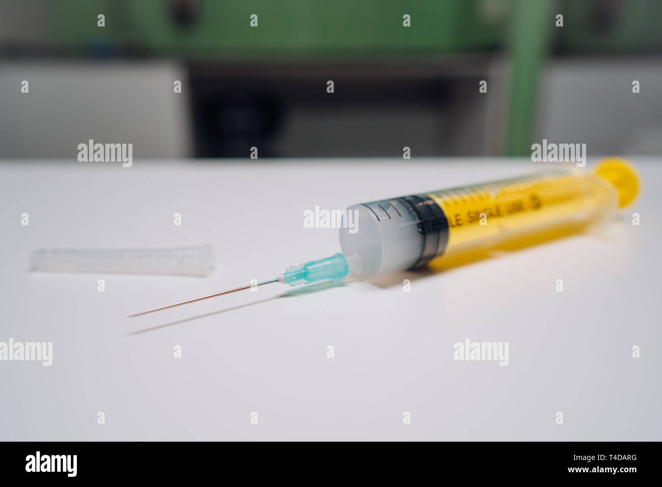 One one-off yellow medical syringe with needle lying Stock Photo - Alamy