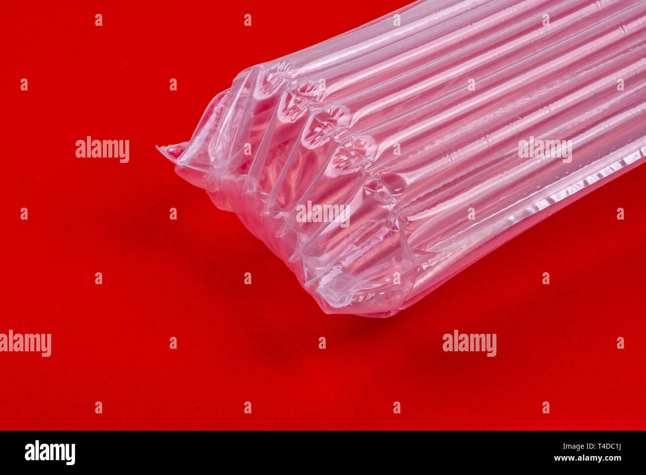 Plastic packaging with air cushion on red background Stock Photo - Alamy