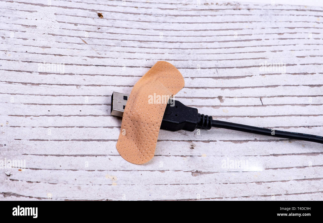 data cable with a plaster glued to the white wood Stock Photo - Alamy