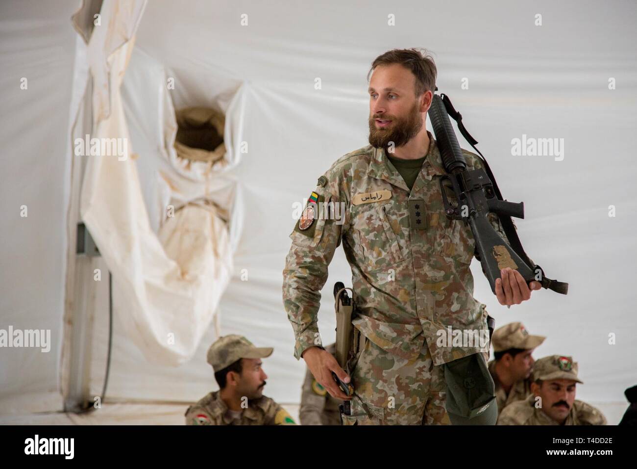 A Danish soldier teaches Iraqi soldiers how to hold an M16 rifle, in a ...