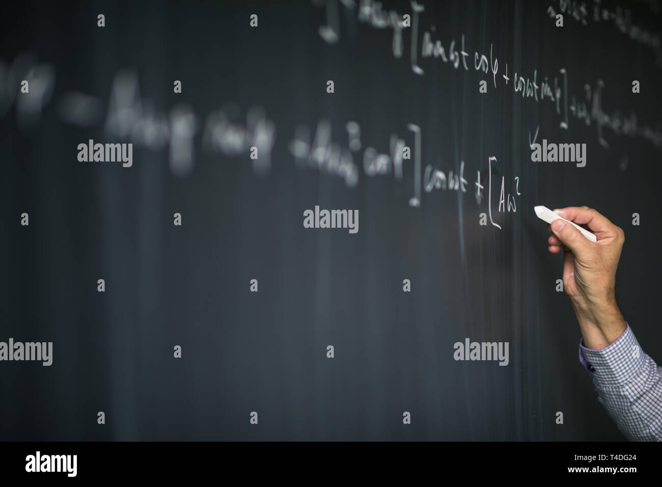 Math teacher by the blackboard during mathclass - detail of the hand ...