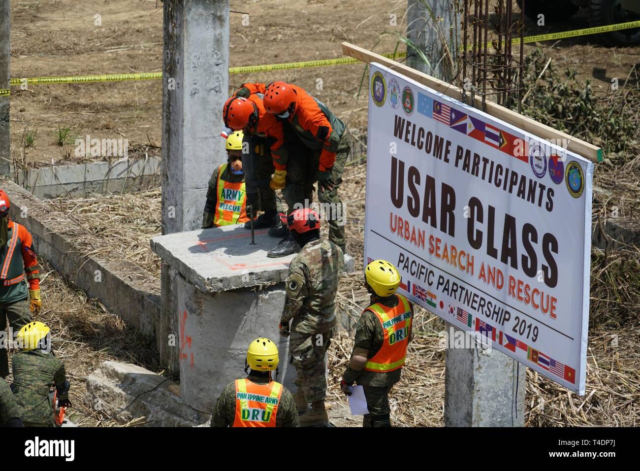 Rescue workers from Armed Forces of the Philippines drill a pilot hole ...