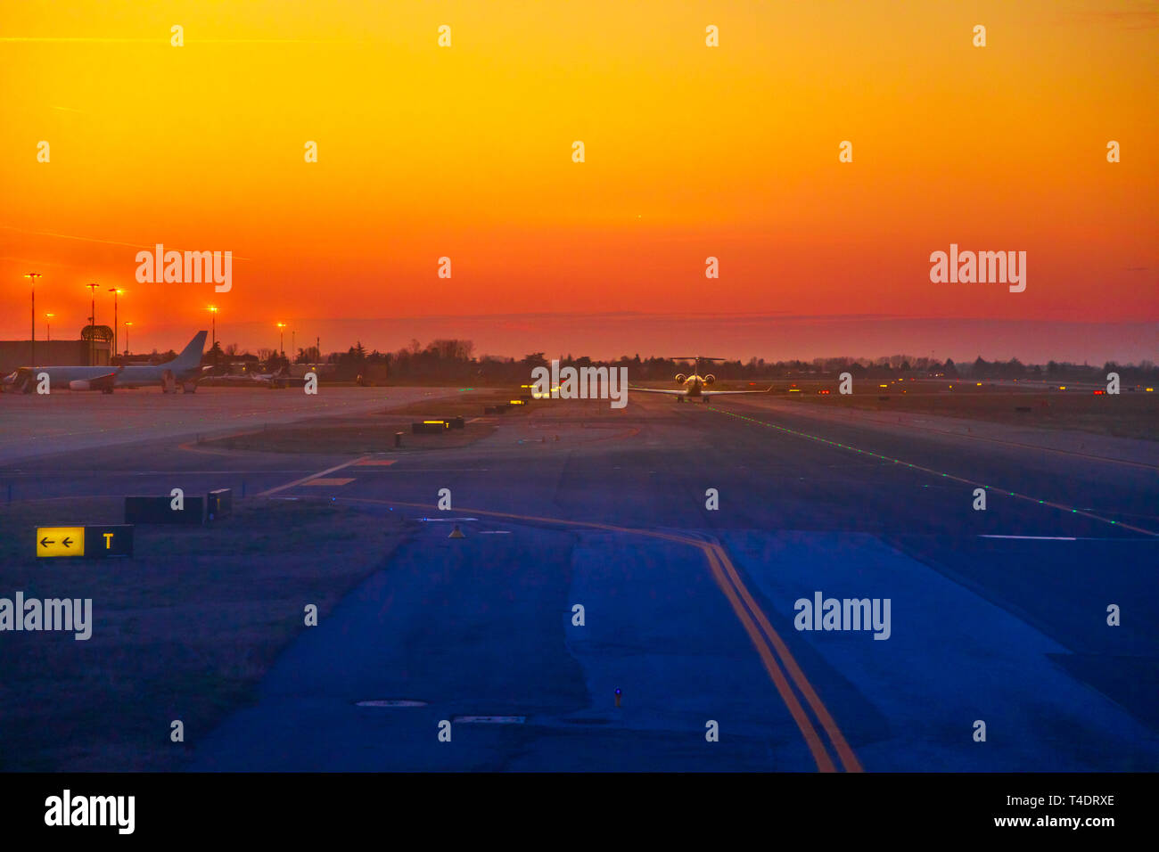 Airplane on airport runway sunset hi-res stock photography and images ...