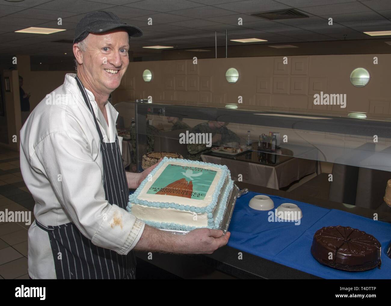 Allan Greer, galley assistant manager and head cook, holds a cake ...