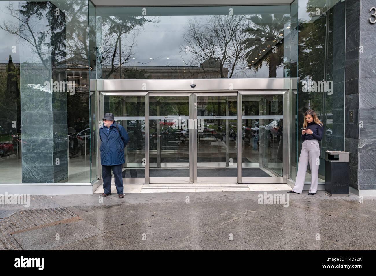 Modern building entrance with people waiting outside Stock Photo - Alamy