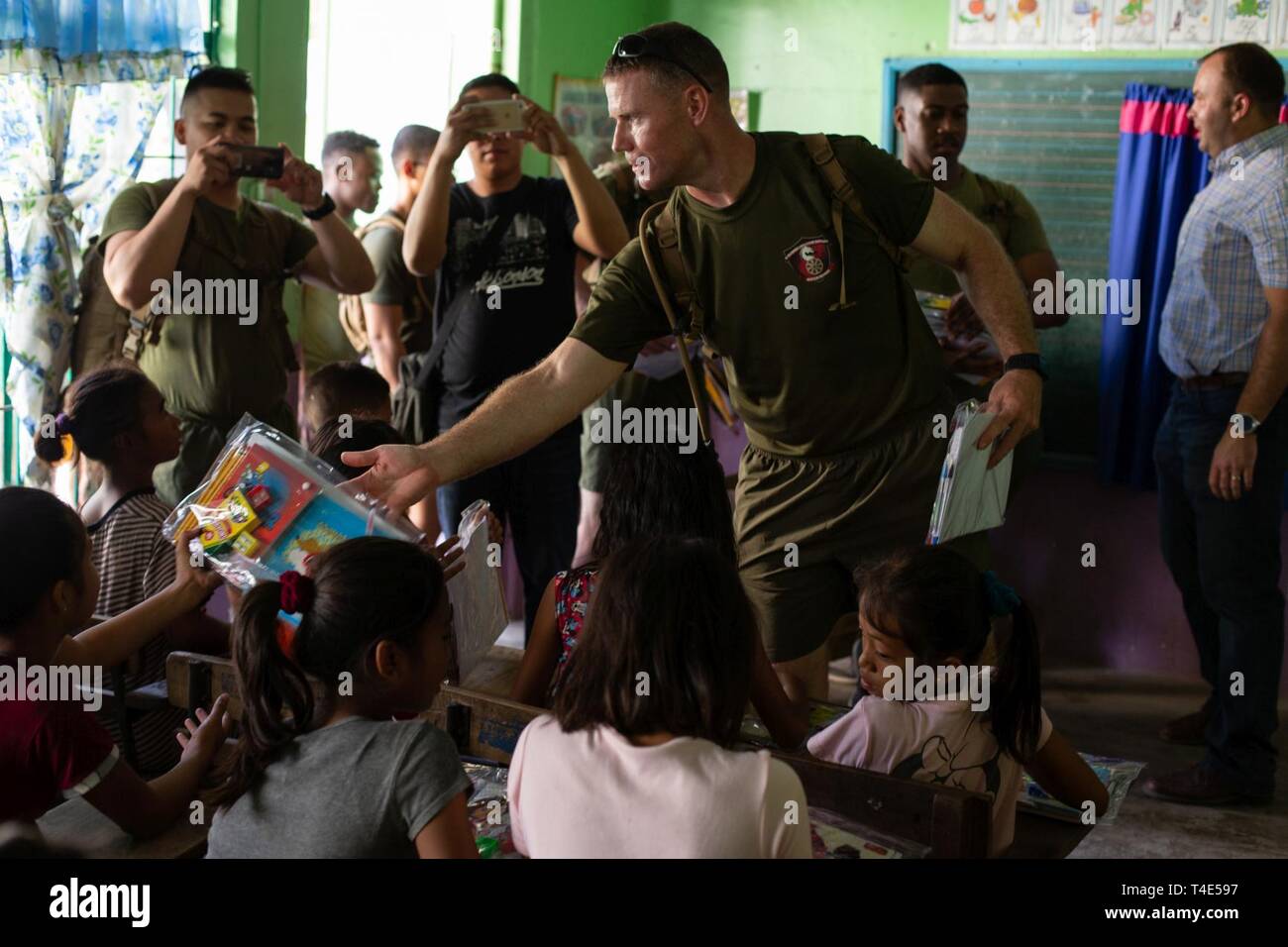 U.S. Marine Corps Lt. Col. Matthew Mulvey passes out school supplies to ...