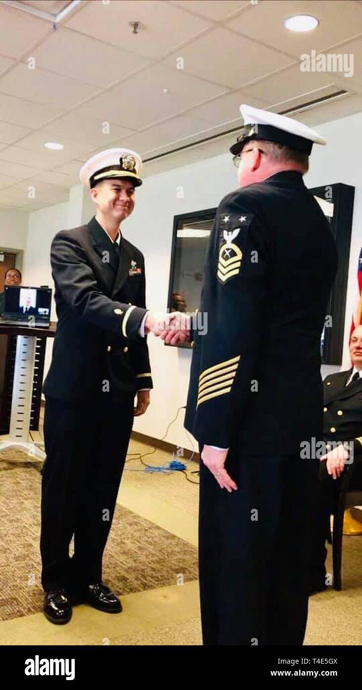Ens. Joshua Scherrer is congratulated by his dad, a retired Navy master ...