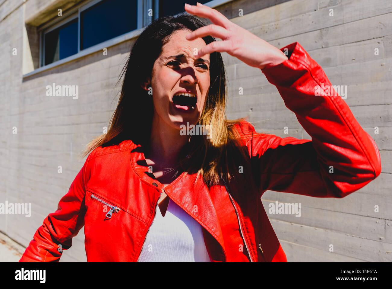 Scared woman is scared and makes a panic face while screaming for help ...