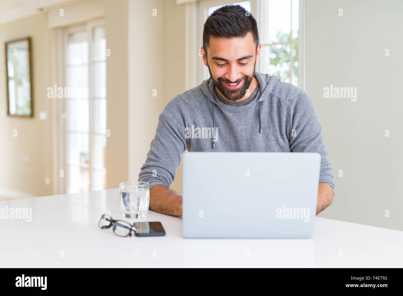 Man smiling working using computer laptop Stock Photo - Alamy