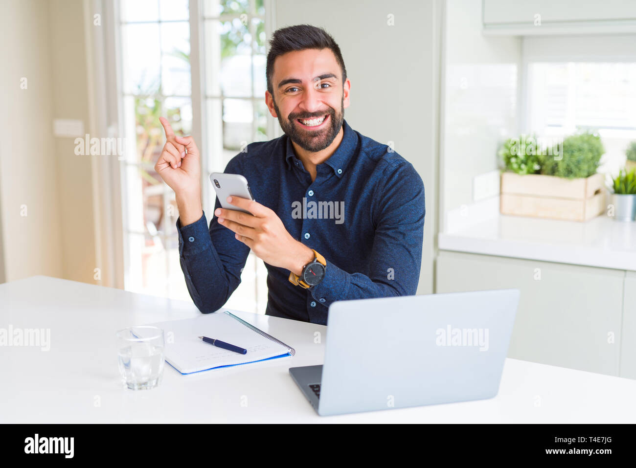Handsome hispanic business man using smartphone and laptop at the ... Handsome hispanic business man using smartphone and laptop at the ...