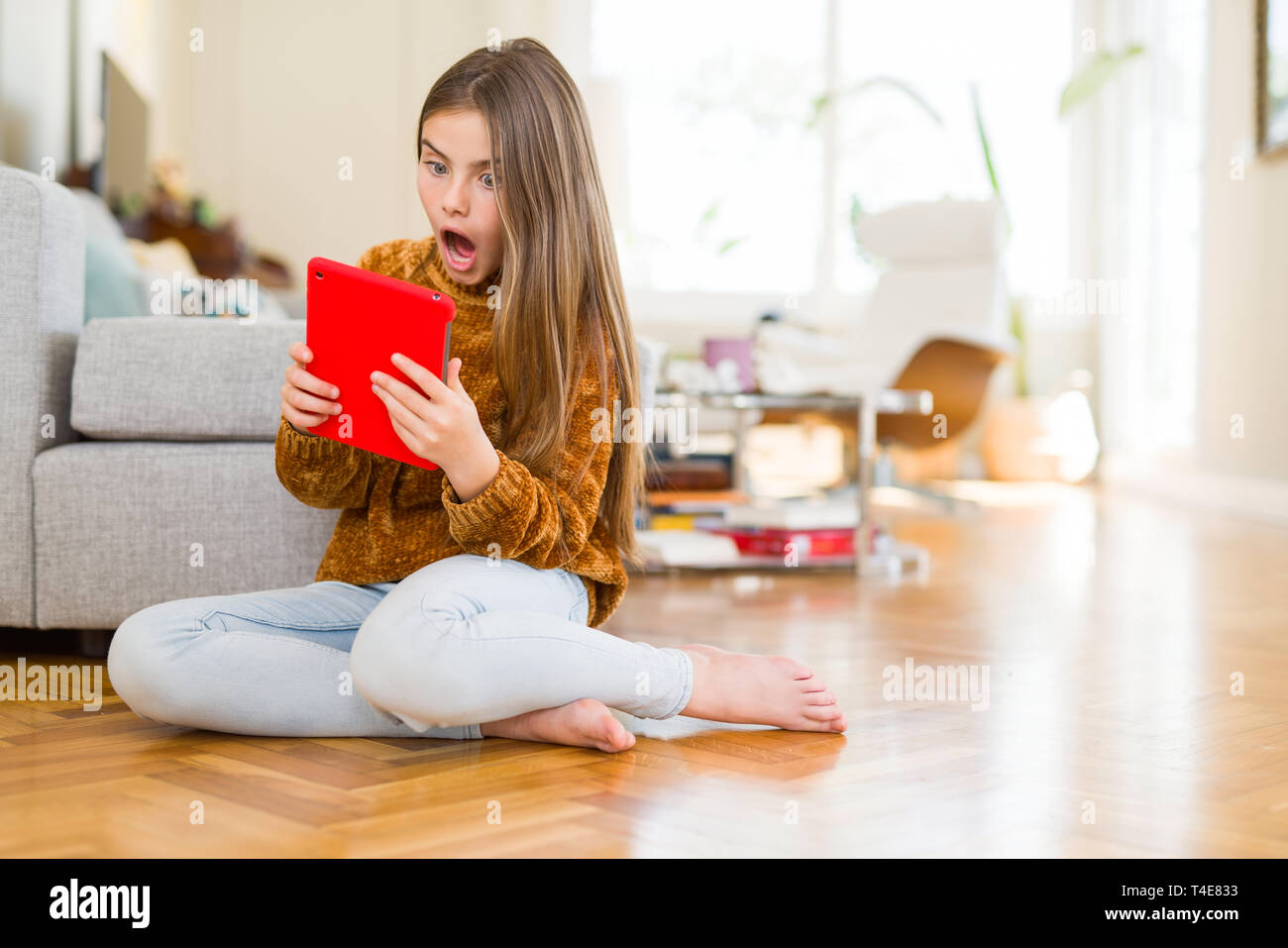 Beautiful young girl kid using digital touchpad tablet sitting on the ...