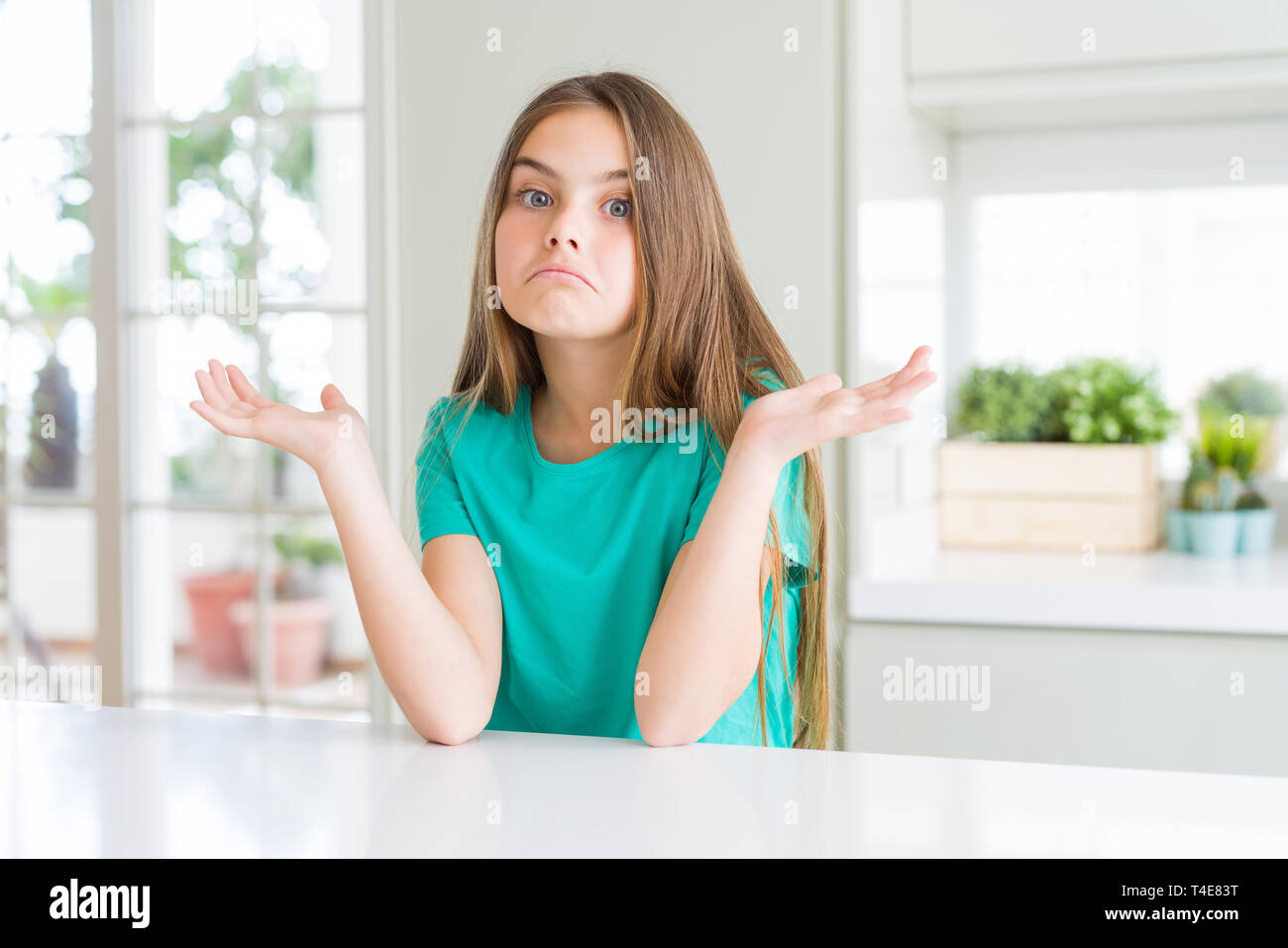 Beautiful young girl kid wearing green t-shirt clueless and confused ...