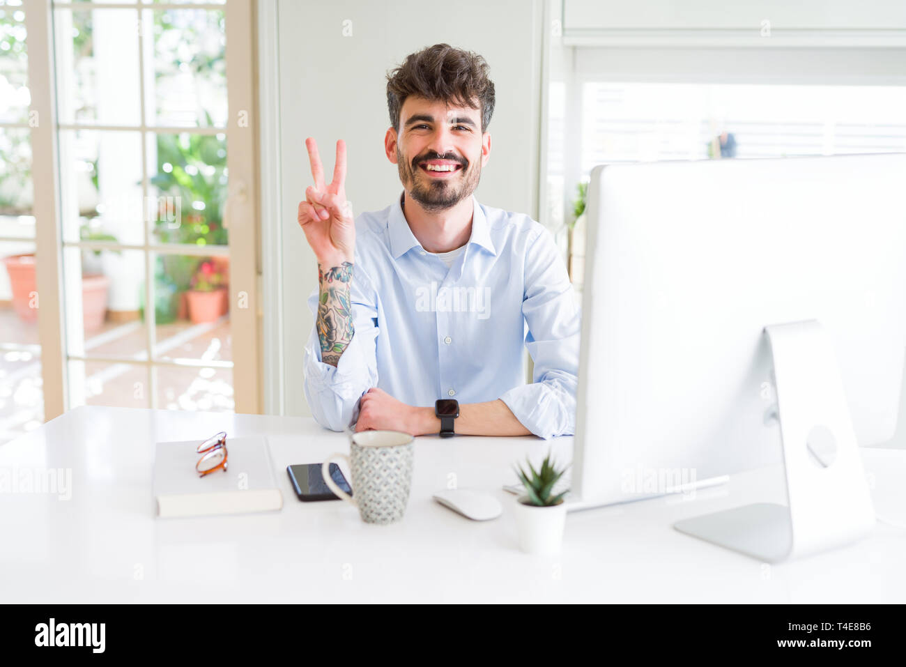 Young business man working using computer smiling with happy face ...