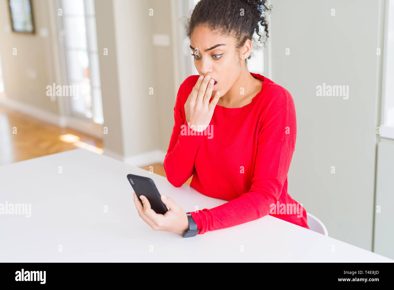 Young african american woman using smartphone texting a message cover ...