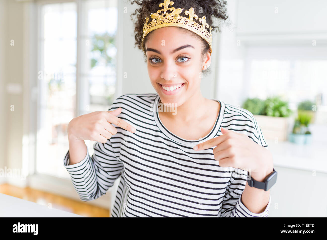 Young african american girl wearing golden queen crown on head looking ...