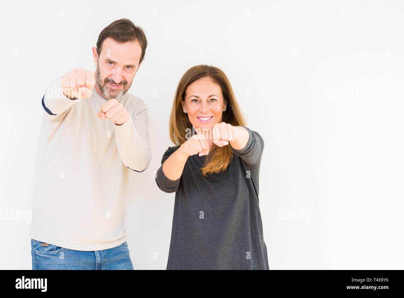 Beautiful middle age couple in love over isolated background Punching ...