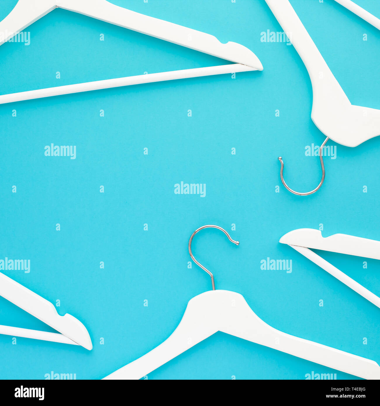 Creative top view flat lay white wooden hangers isolated bold blue ...