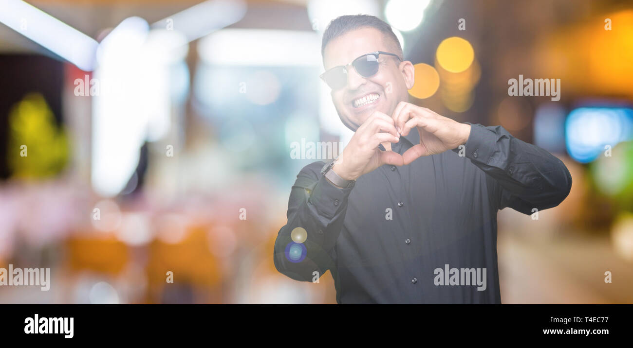 Middle age arab man wearing sunglasses over isolated background smiling ...