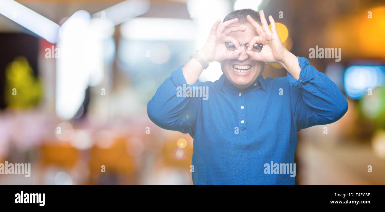 Middle age arab man wearing glasses over isolated background doing ok ...