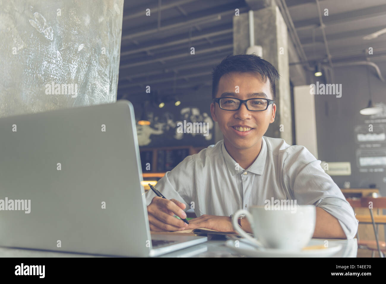 Smiling asian worker writing hi-res stock photography and images - Alamy