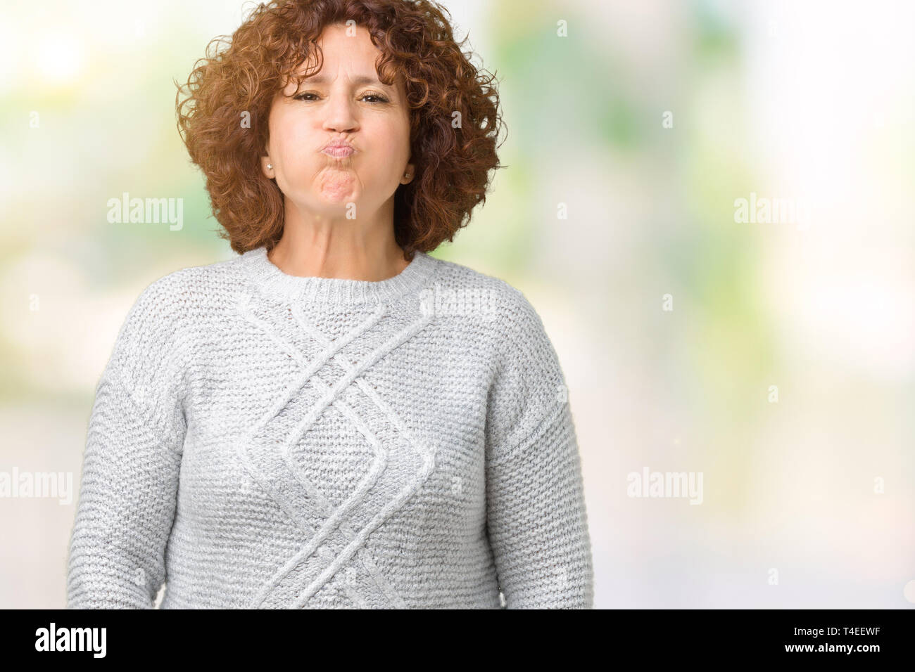 Beautiful middle ager senior woman wearing winter sweater over isolated ...