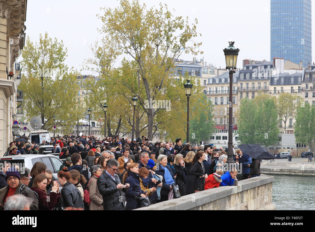 A crowd of people look over towards the remains of the Notre Dame ...