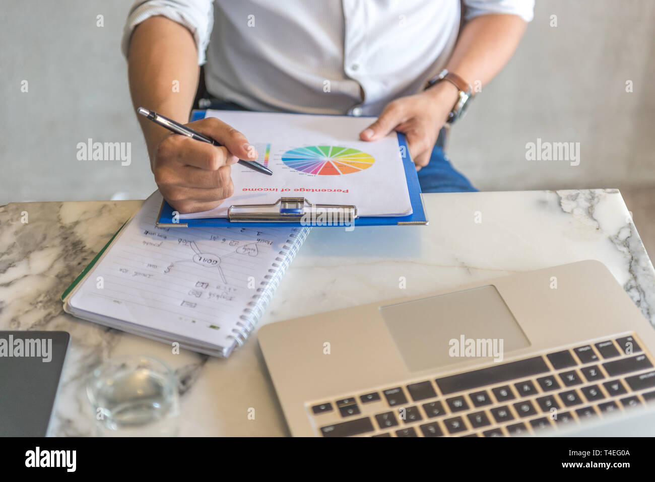 Man in white shirt reading financial document Stock Photo - Alamy