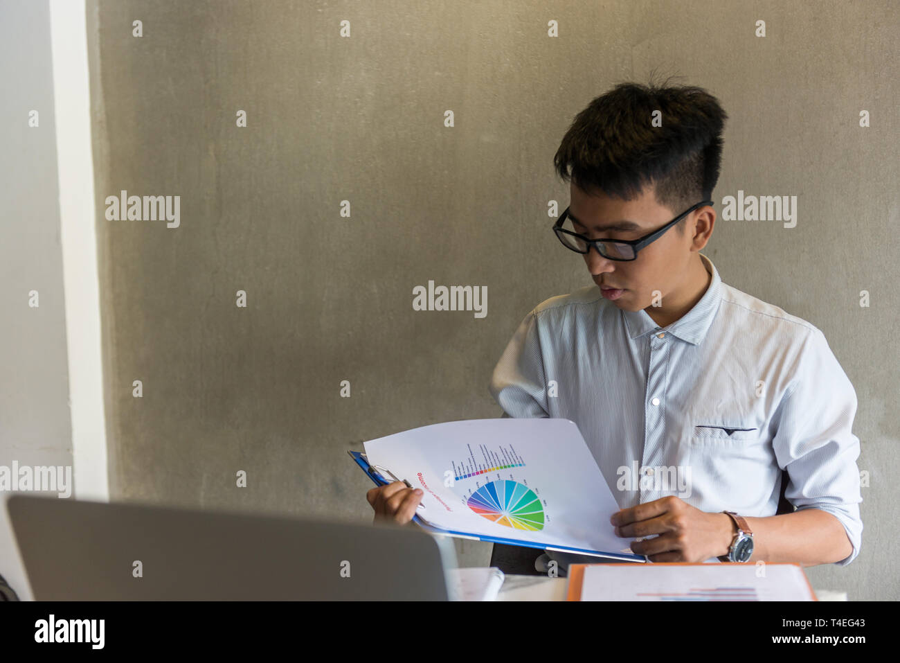 Asian office man checking data on the document Stock Photo - Alamy