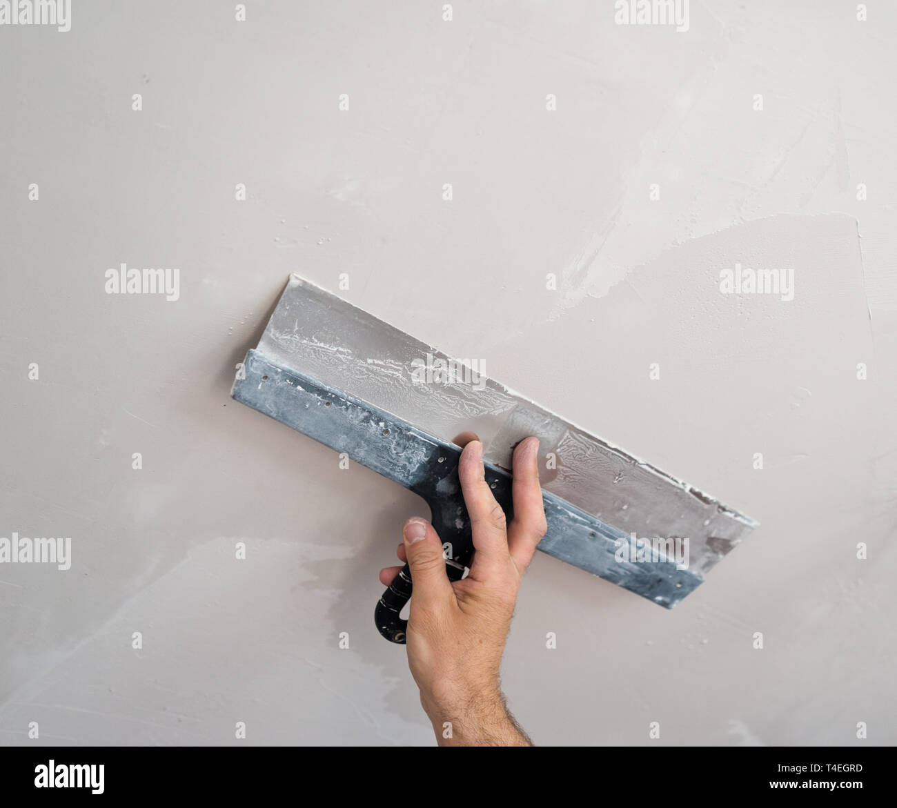 Hand of builder renovating a ceiling Stock Photo - Alamy