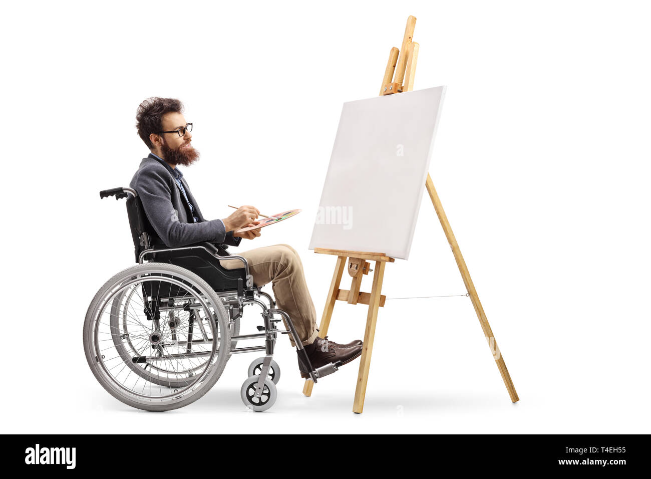 Disabled male artist in a wheelchair painting on a canvas isolated on ...