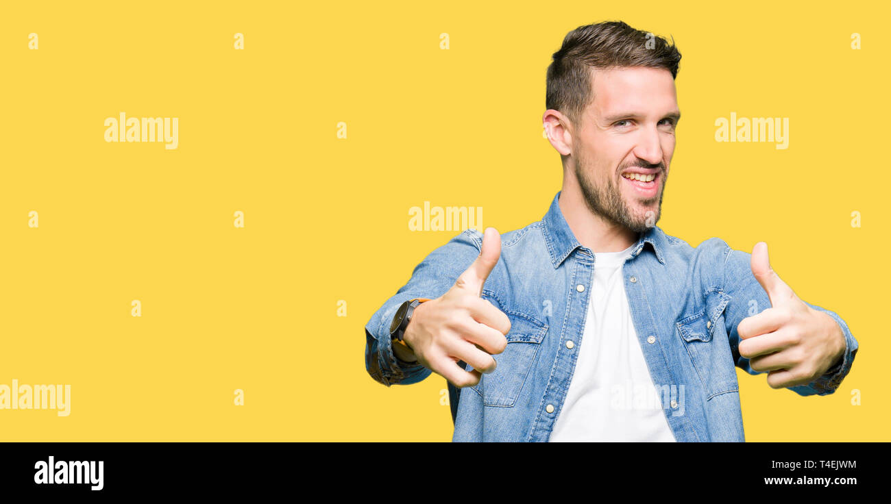 Handsome man with blue eyes and beard wearing denim jacket approving ...