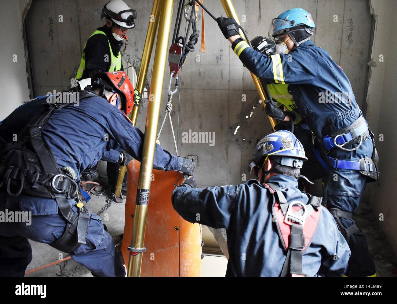 U.S. military firefighters pull up a rescue dummy through a hole in the ...
