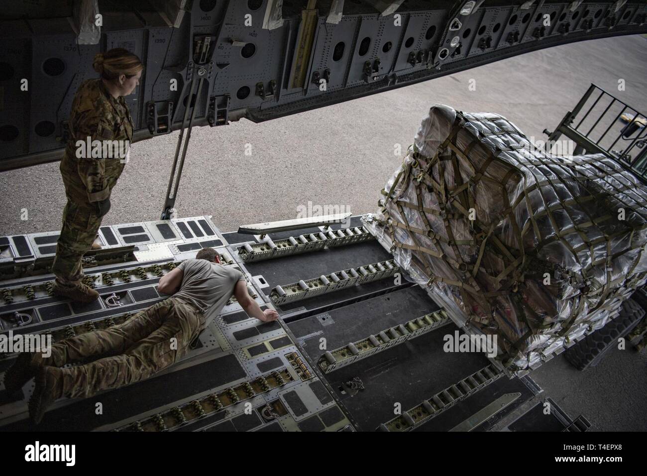 A U.S. Air Force loadmaster helps guide a forklift to the back of a C ...