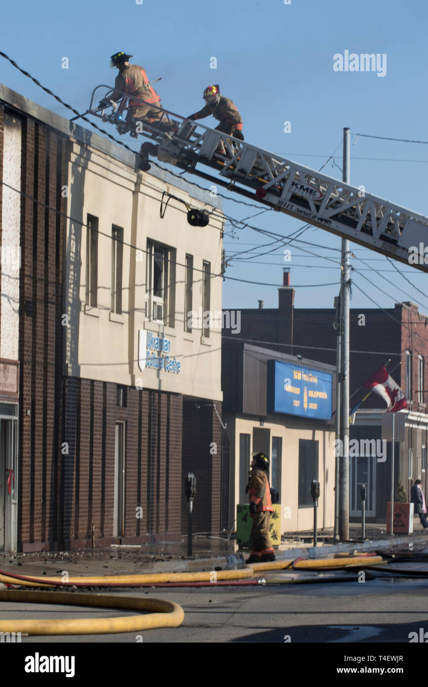 Ontario Canada April 13 2019:Fire fighters working on ladder putting ...
