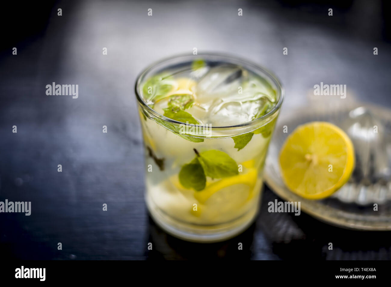 Mojito drink in a transparent glass on wooden surface with white rum ...