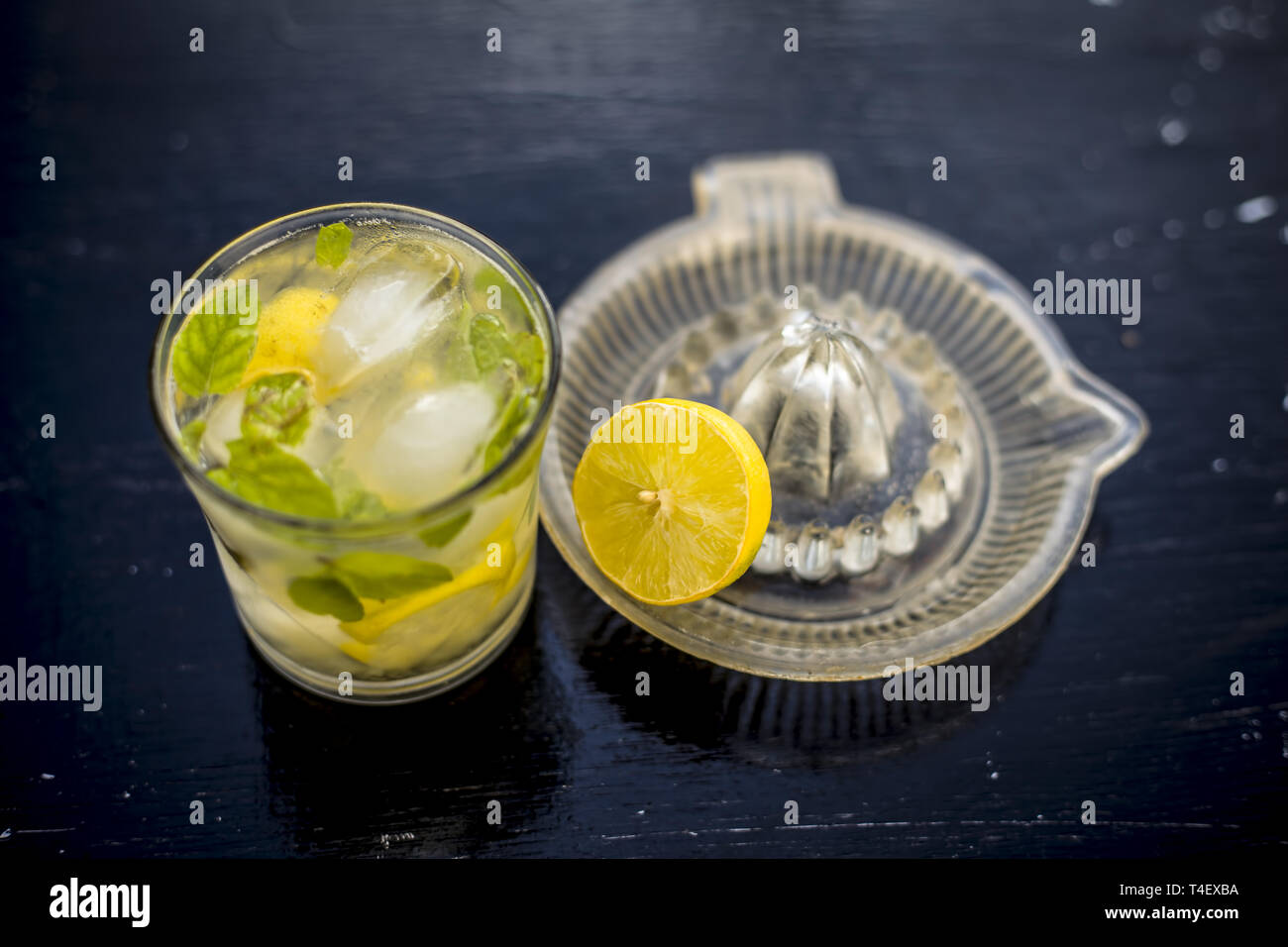 Mojito drink in a transparent glass on wooden surface with white rum ...