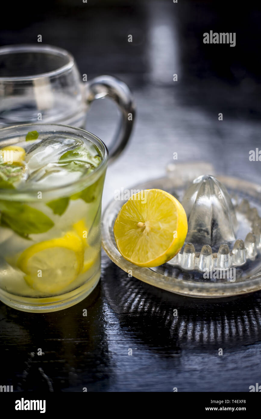 Mojito drink in a transparent glass on wooden surface with white rum ...