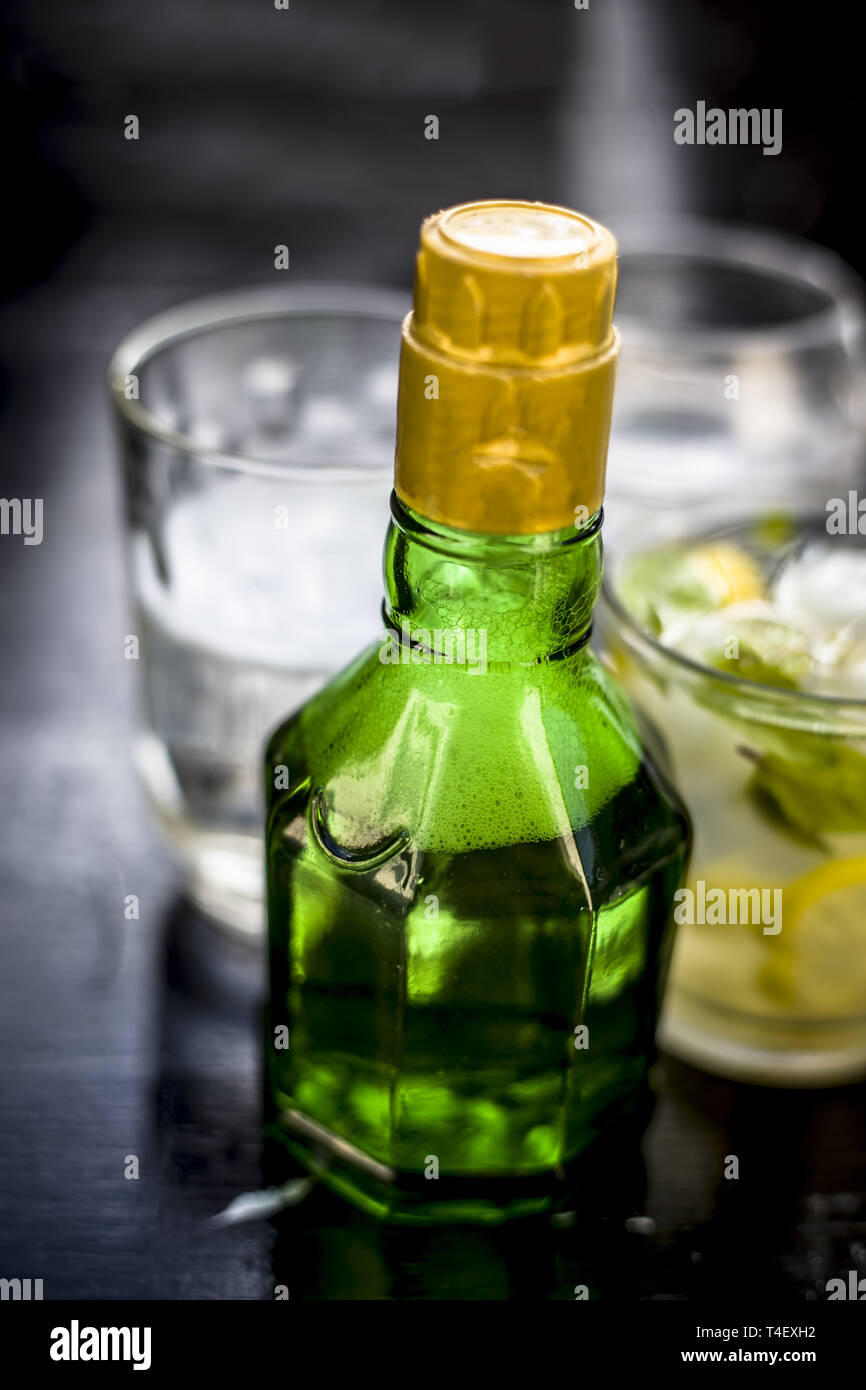 Mojito drink in a transparent glass on wooden surface with white rum ...