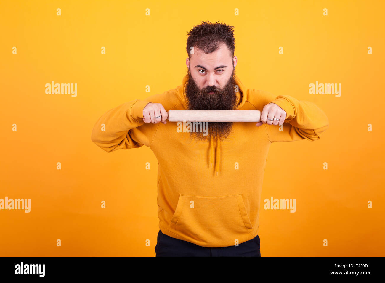 Cool bearded man using kitchen paddle and looking at the camera over ...